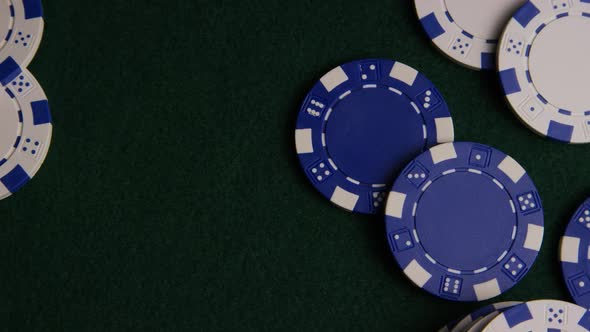 Rotating shot of poker cards and poker chips on a green felt surface ...