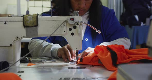 Mixed race woman using sewing machine in factory, Stock Footage | VideoHive