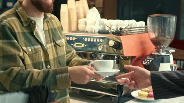 Handsome male barista gives coffee to a Man. Man buys coffee in a ...