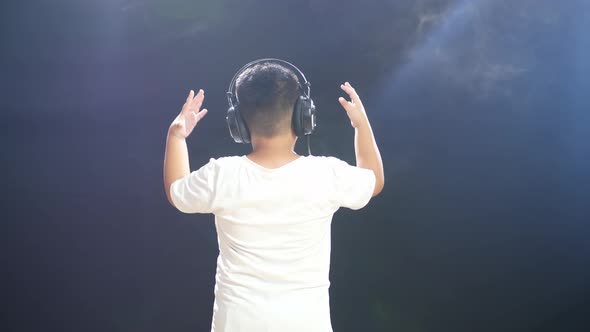Back View Of A Young Boy With Headphone Rapping On The White Smoke ...