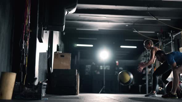 A Fitness Athletes are Training in the Dark Gym, Stock Footage | VideoHive