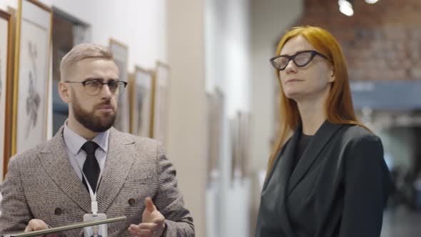 Male Gallery Docent Showing Art Exhibition to Woman, Stock Footage