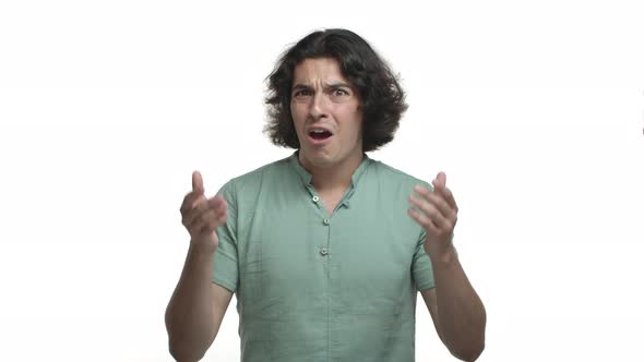 Frustrated Hispanic Man in Green Shirt Shaking Head in Denial and ...