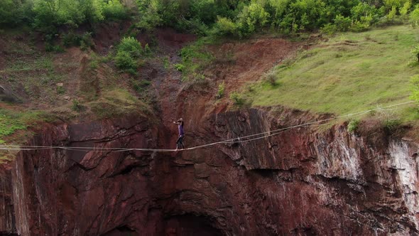 High Angle View on a Man Walking the Tightrope Over the Scary Pit ...
