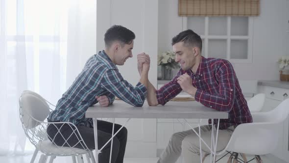 Caucasian Twin Brothers Competing in Armwrestling at Home. Two Positive ...