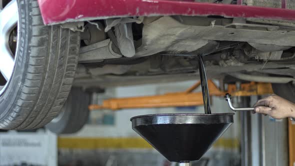 Draining Used Oil From A Car Engine In A Car Repair Shop, Stock Footage