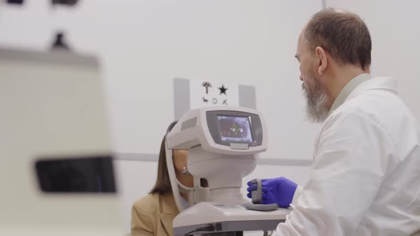 Optometrist Checking Eyes of Female Patient with Autorefractor, Stock ...