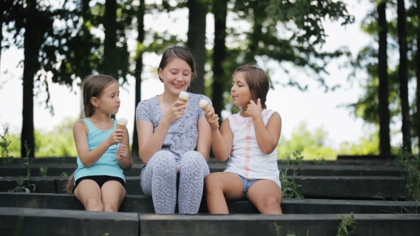 Three Children Sitting On a Bench In The Park And Eat Ice Cream, Stock ...