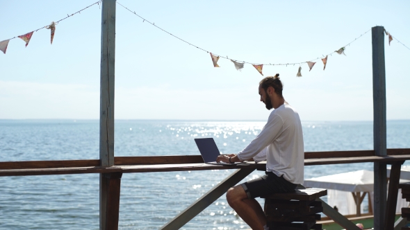 Man Uses Laptop On Background Of Sea, Stock Footage | VideoHive