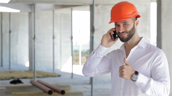 Construction Engineer Talking On The Phone At The Building Under ...