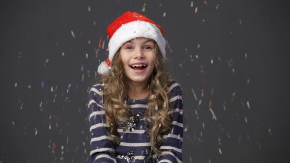 Little Girl in a Christmas Cap Throwing up Confetti, Stock Footage