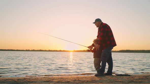 Happy Granddad and Little Boy are Fishing in Sunset Time Old Fisher and ...