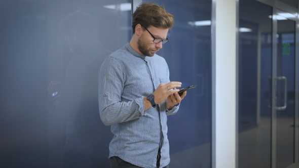 Job Applicant Checking His Mobile Phone In Office Corridor, Stock Footage