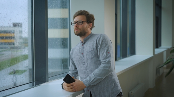 A Man Standing In Corridor Holding And Looking Out The Window., Stock ...
