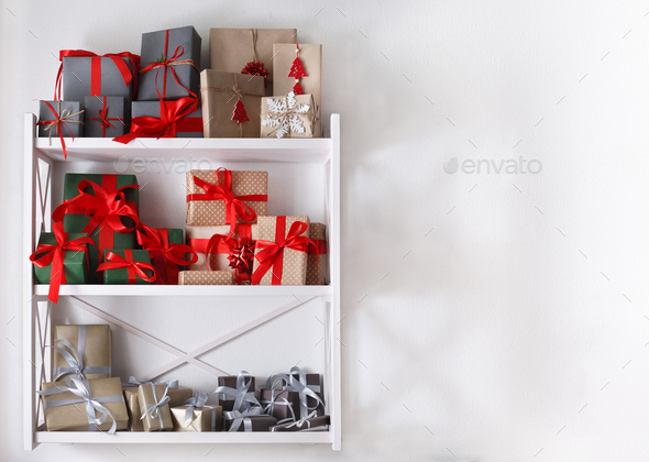 Christmas gift boxes on white shelves at wall background Stock Photo by ...