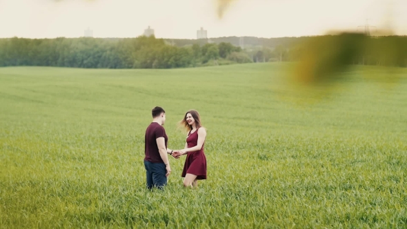 Loving Couple Hug, Standing in a Field. They Smile Happily, Look at ...