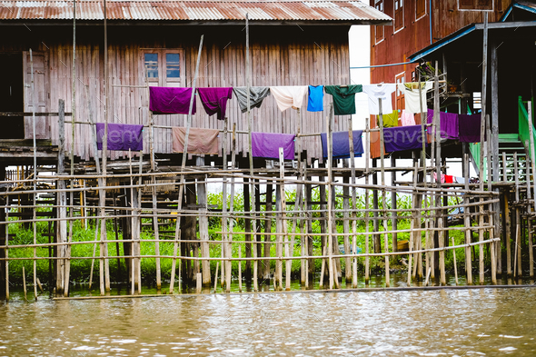 Traditional wooden houses on Inle lake with drying colorful clothes ...