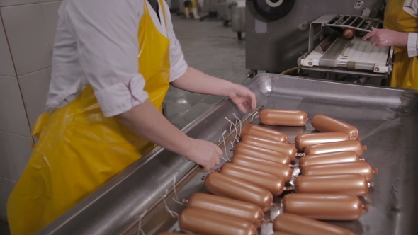Production of Sausages. Worker Operates Meat Processing Equipment at a ...
