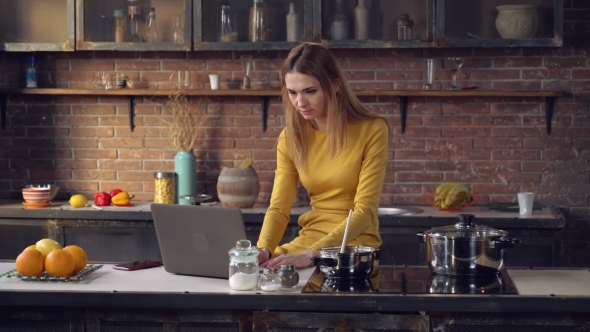 Young Lady Using Computer and Cooking Lunch., Stock Footage | VideoHive