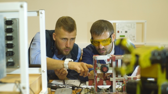Engineering Working in the Lab, Adjusting a 3D Printer's Components ...