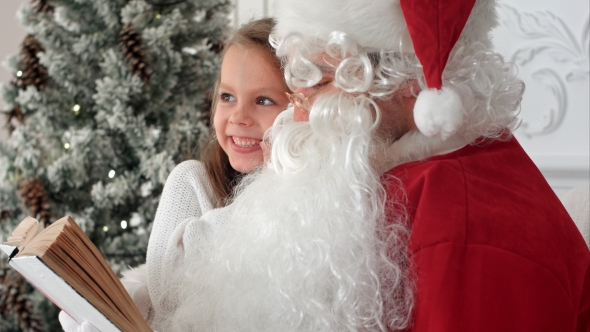 Santa Claus Reading a Book with Cute Girl Near the Christmas Tree ...