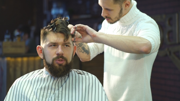 Young Handsome Barber Making Haircut of Attractive Bearded Man in ...