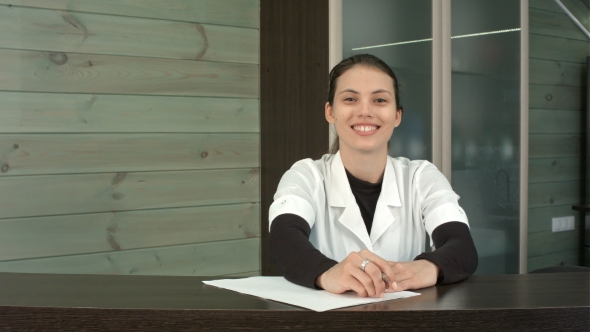 Beauty Salon Receptionist Filling in Form and Greeting Customers with a ...