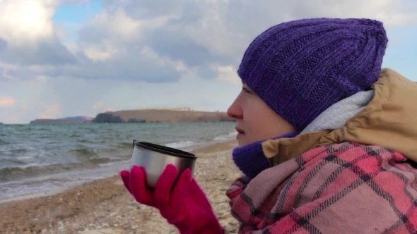 Girl Sits on the Shore of the Sea and Drinks a Hot Tea, Stock Footage