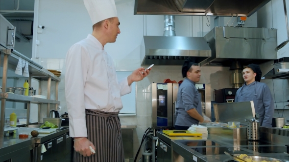 Chef Reading Something From His Phone and Talking To One of the Cook ...
