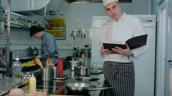 Chief Chef with Recipe Book Watching the Cooking Process in the ...
