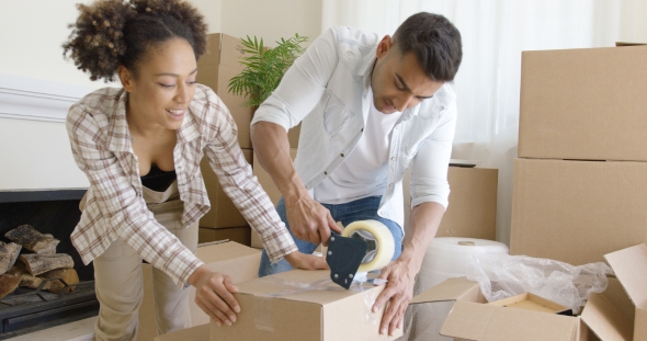 Couple Taping Boxes As They Pack Up Their Home, Stock Footage | VideoHive
