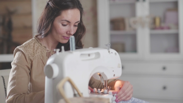 A Woman Sitting at a Modern Sewing Machine Enjoying Crafts and Hobbies ...