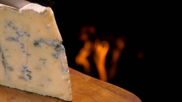 Blue Cheese Cut on the Background of a Fireplace, Stock Footage | VideoHive