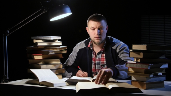 Man Reading a Book and Writes in a Notebook. Black Background, Stock ...