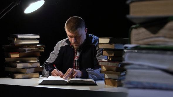 Man Reading a Book and Writes in a Notebook. Black Background, Stock ...