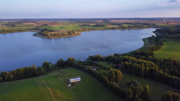 Aerial shot of a secluded lake, surrounded by fields and farms ...