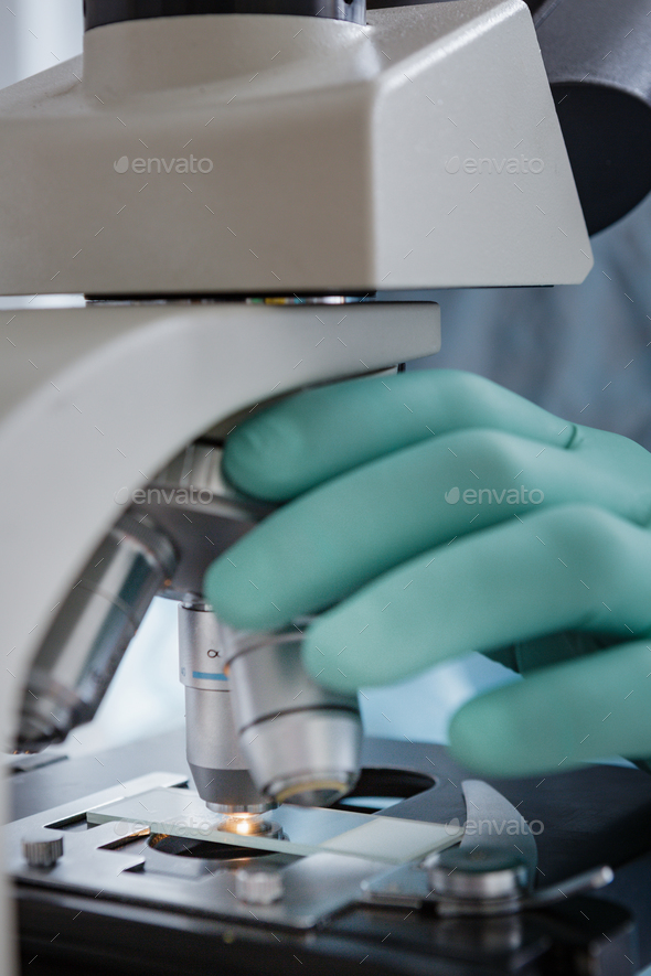 Close up view of glass under microscope Stock Photo by KonstantinKolosov