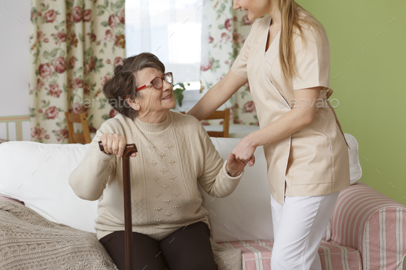 Caregiver helping senior woman Stock Photo by bialasiewicz | PhotoDune