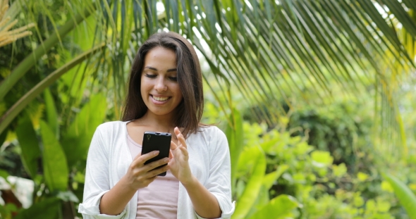 Young Woman Using Cell Smart Phone Smiling Looking In Camera Outdoors ...