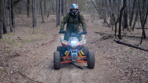 Man in Protective Equipment and Helmet Operating ATV Moving Along the ...