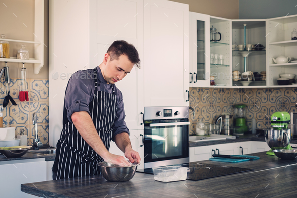 Chef cook working on a modern kitchen at home Stock Photo by Nejron