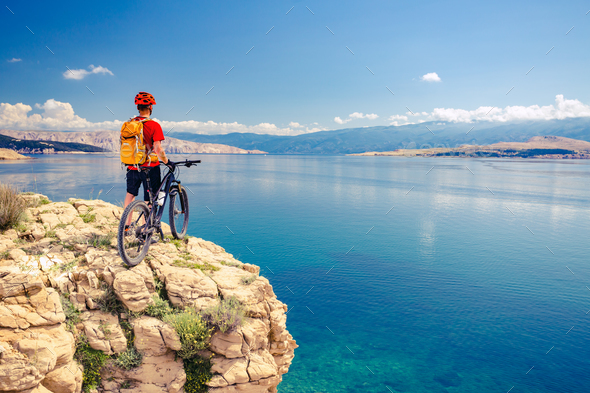 Mountain biker looking at view and riding a bike Stock Photo by blas