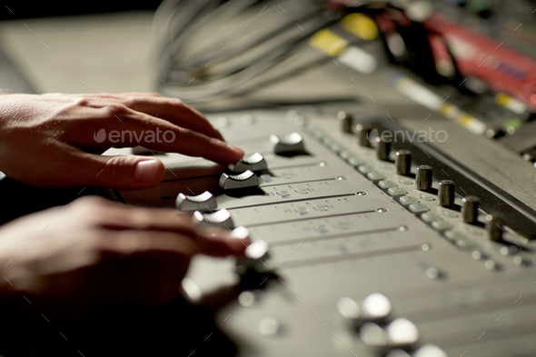 hands on mixing console in music recording studio Stock Photo by dolgachov