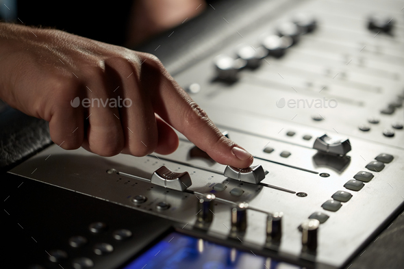 hand with mixing console in music recording studio Stock Photo by dolgachov