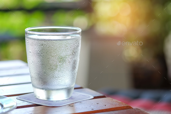 Water glass on wooden table. Stock Photo by poungsaed_eco | PhotoDune