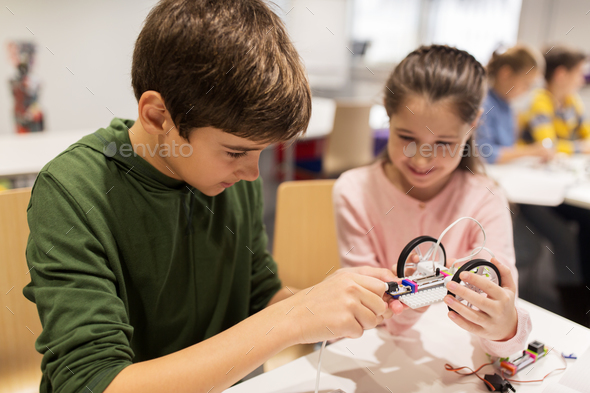 happy children building robots at robotics school Stock Photo by dolgachov