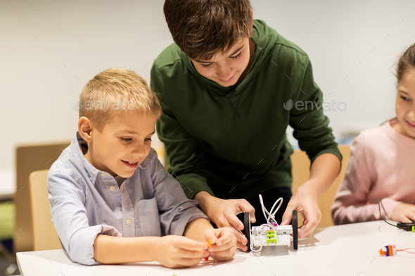 happy children building robots at robotics school Stock Photo by dolgachov