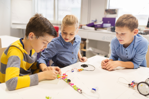 happy children building robots at robotics school Stock Photo by dolgachov
