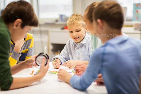 happy children building robots at robotics school Stock Photo by dolgachov