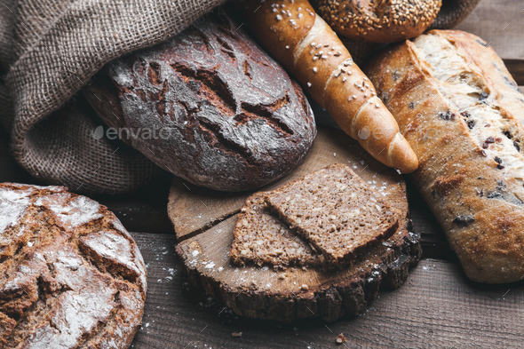 Delicious fresh bread inside a sack on wooden background Stock Photo by ...
